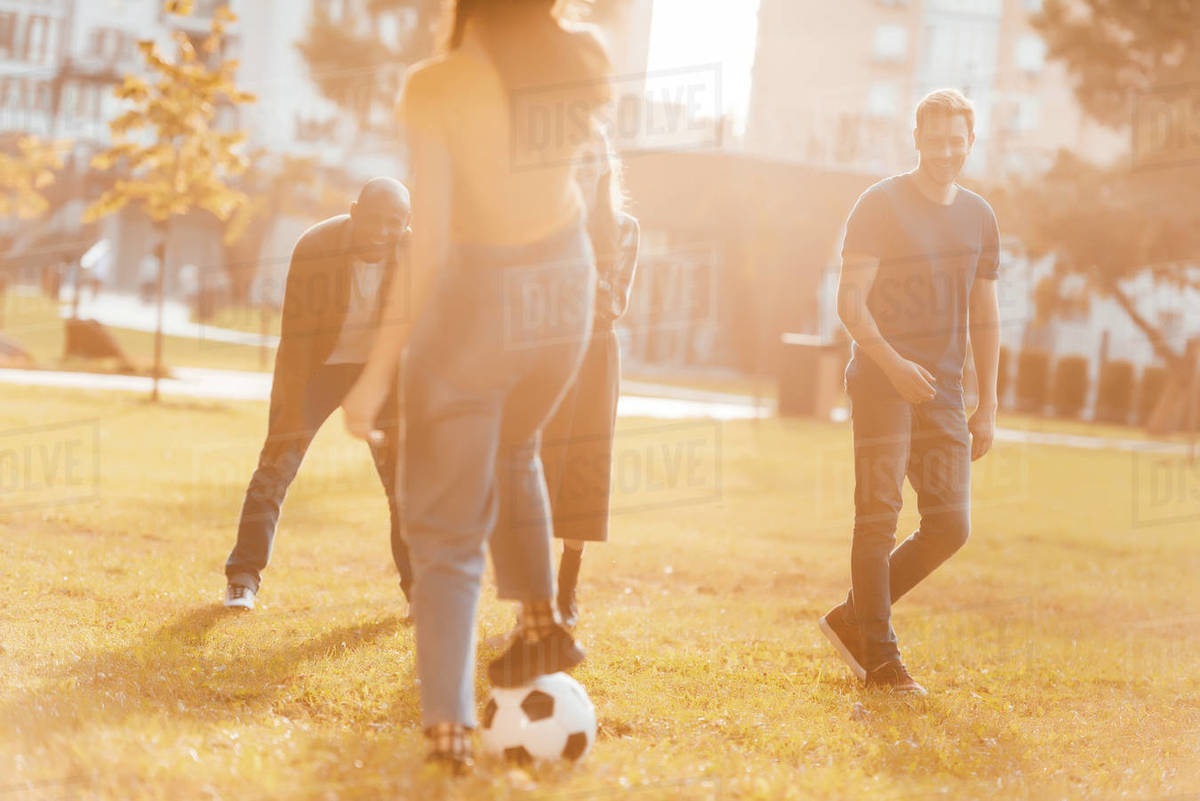 Multicultural friends playing soccer together in park - Royalty-free ...