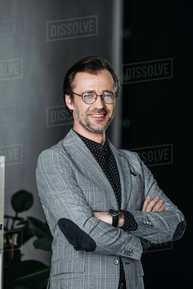 Portrait of confident middle aged businessman in eyeglasses standing ...