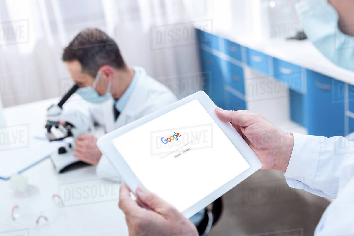 Cropped shot of lab technician in chemical laboratory, holding a ...