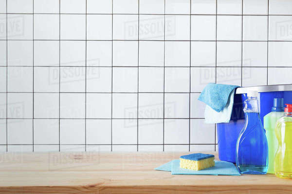 Various cleaning products, sponge, rags and bucket on tabletop - Stock ...
