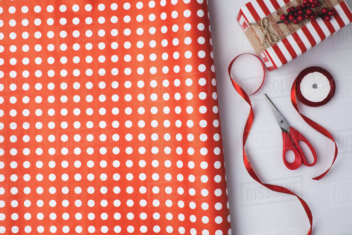 Flat lay with Christmas present, wrapping paper, ribbon and scissors ...