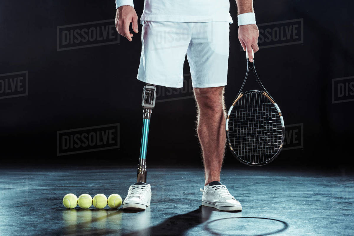 Cropped shot of tennis player with racket in hand and tennis balls on ...