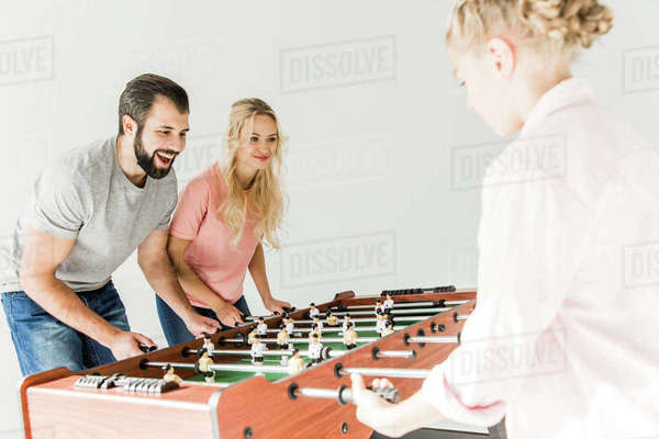 Selective focus of smiling young family playing foosball isolated on ...