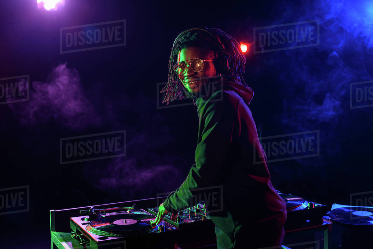 Professional African American club dj with sound mixer in nightclub ...