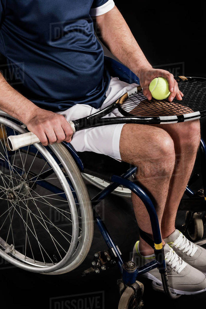 Cropped shot of disabled sportsman sitting in wheelchair and holding ...