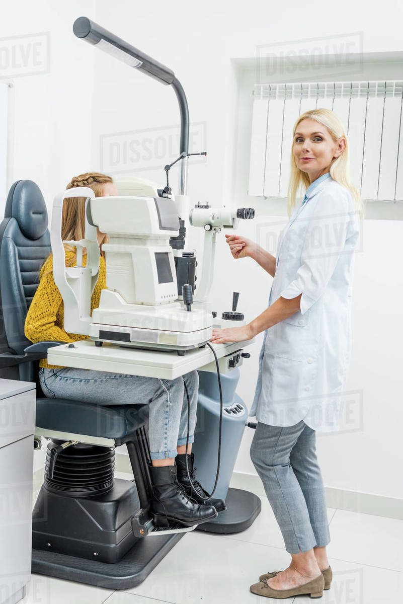Optician examining patient through slit lamp in clinic - Stock Photo ...