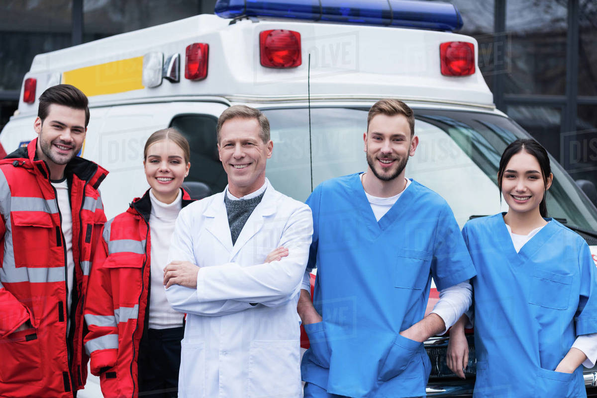 Happy ambulance doctors working team standing in front of car - Royalty ...