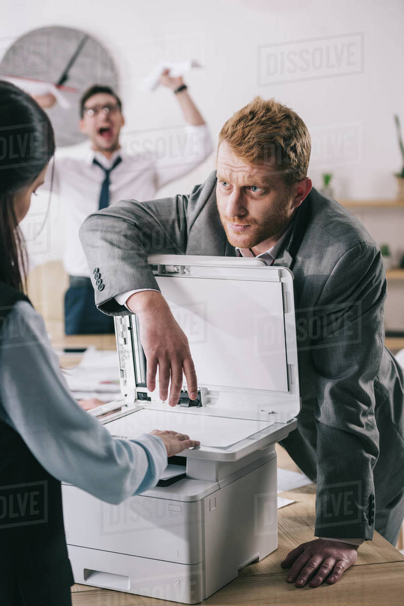 businessman helping colleague with copier at office - Stock Photo ...