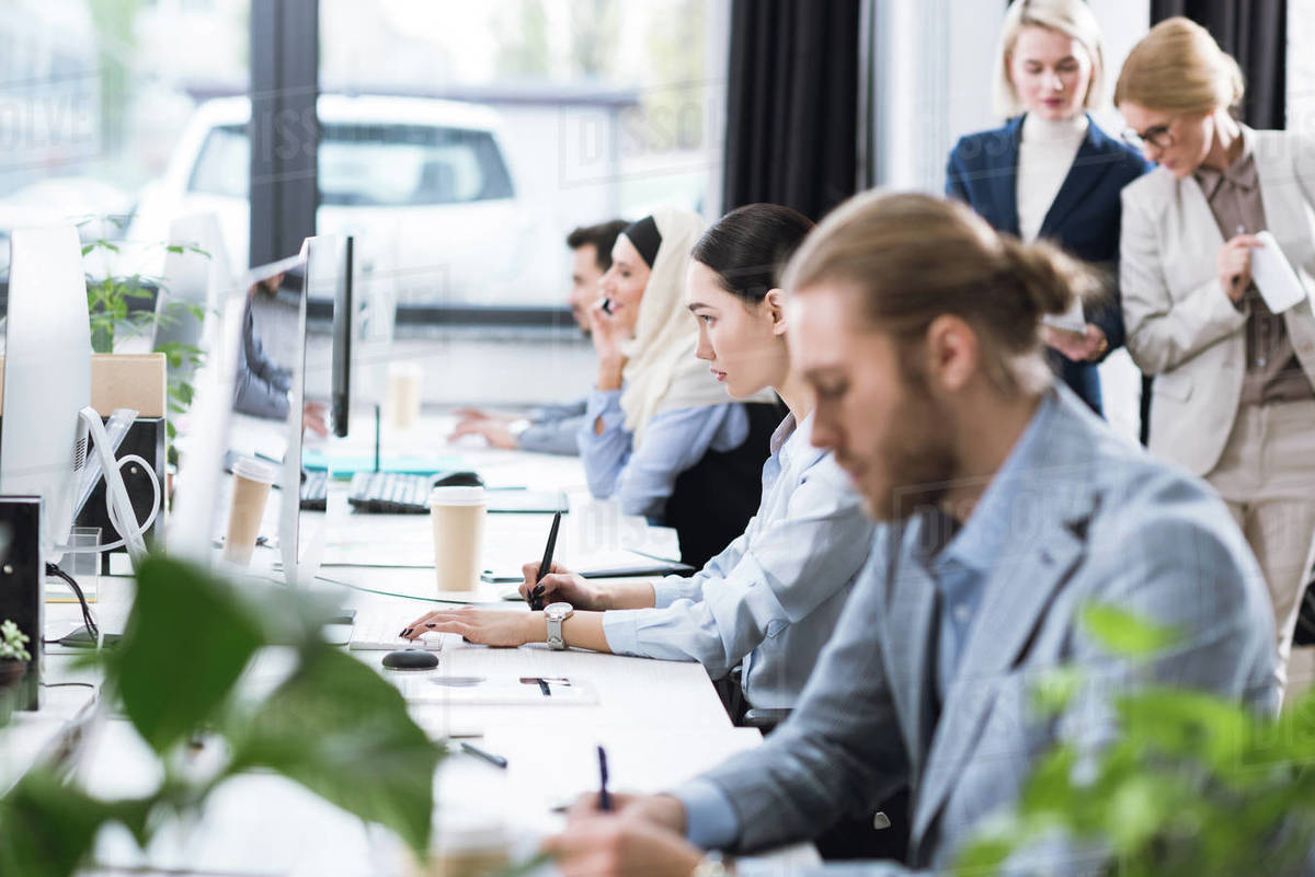 Selective focus of focused multicultural business people working in ...