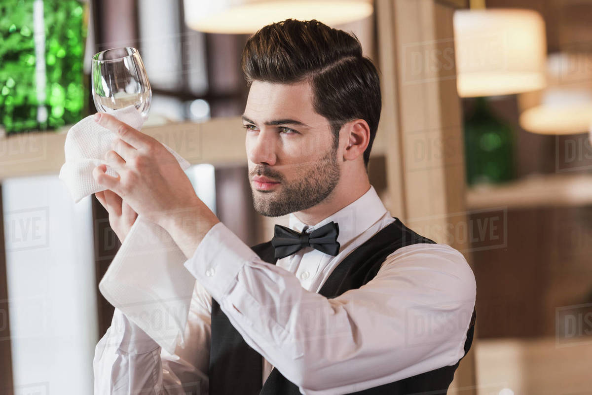 Handsome waiter looking at clean wineglass - Royalty-free Stock Photo ...