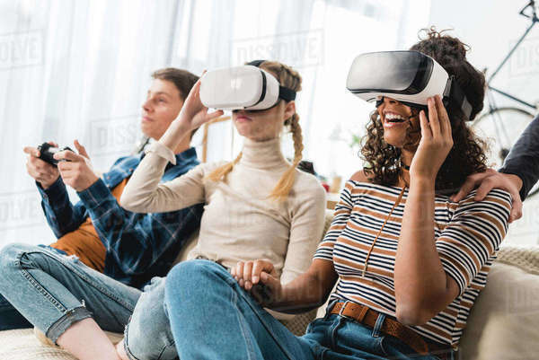 Multiethnic teen girls watching something with virtual reality headsets ...