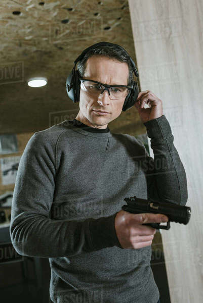 Handsome man with gun in shooting range - Royalty-free Stock Photo ...