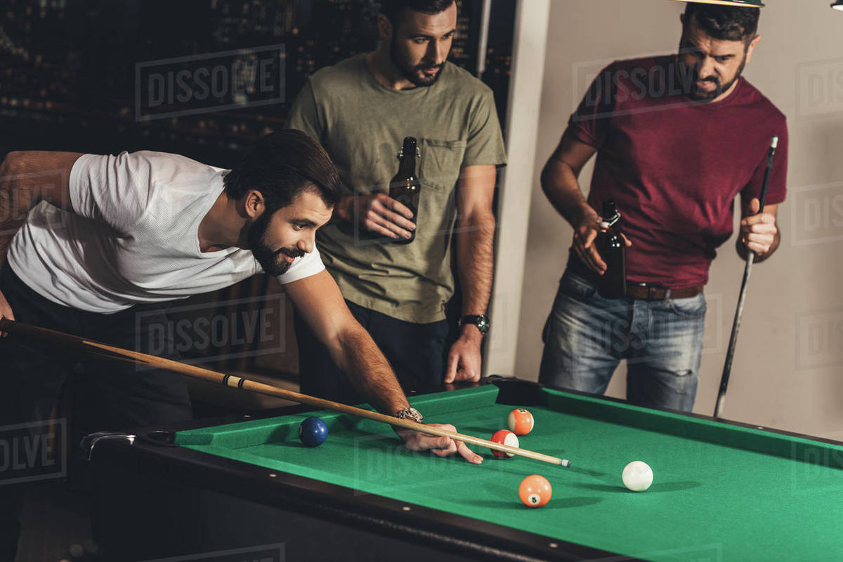 Group of young successful handsome men playing in pool at bar - Royalty ...