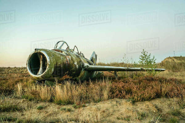old rusty airplane lying in field - Stock Photo - Dissolve