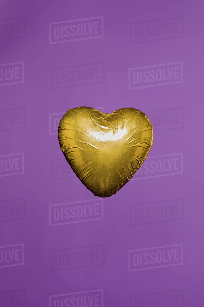 Heart shaped candy in golden wrapper isolated on purple - Royalty-free ...