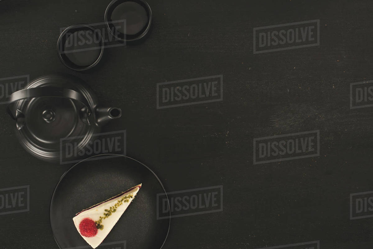 Top view of tea set and delicious dessert on black - Stock Photo - Dissolve