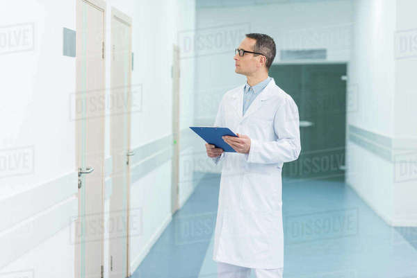 male doctor in white coat holding diagnosis in hospital - Royalty-free ...