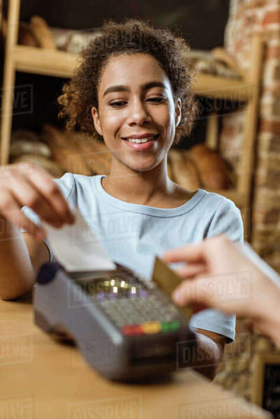 Close-up shot of happy cashier with point of sale terminal receiving ...