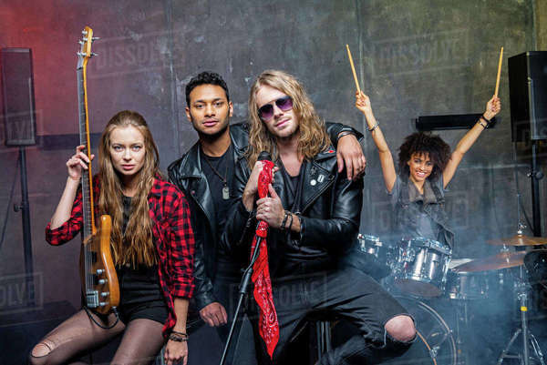 Rock band posing in studio after rehearse - Stock Photo - Dissolve