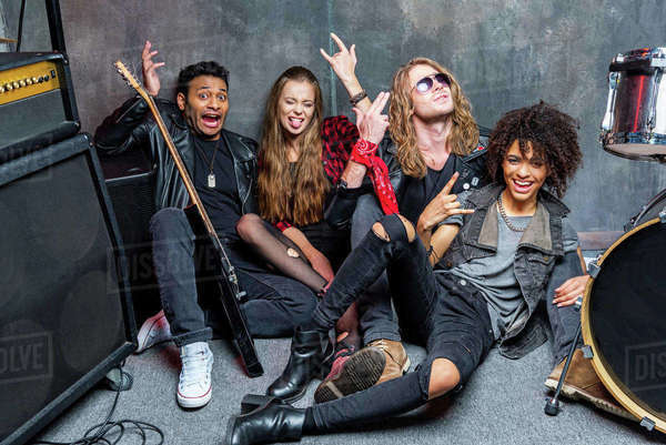 Rock band sitting on floor while resting after rehearse in studio, rock ...