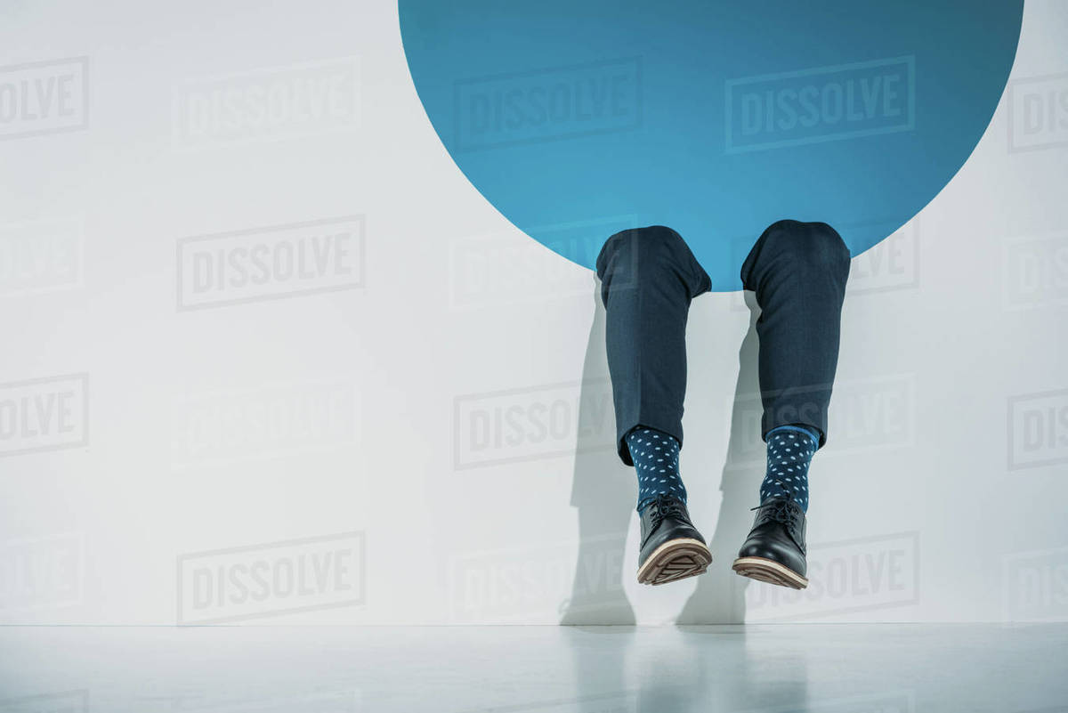 Low section of stylish young man falling into hole on grey - Royalty ...