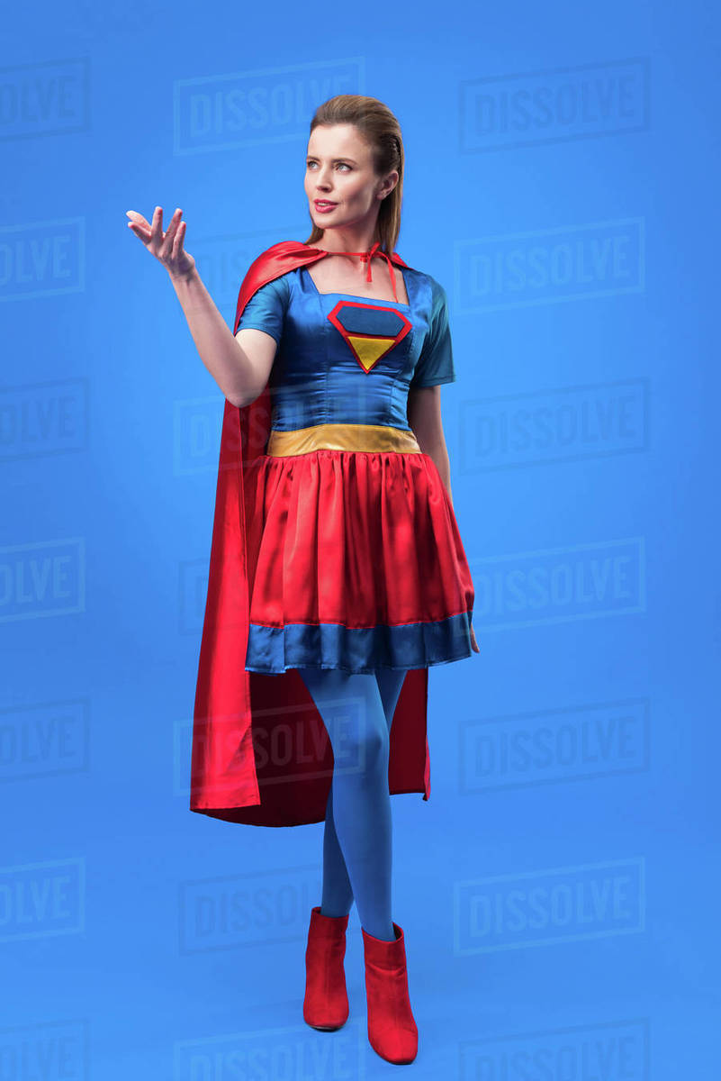 Attractive woman in superhero costume with cape gesturing isolated on ...