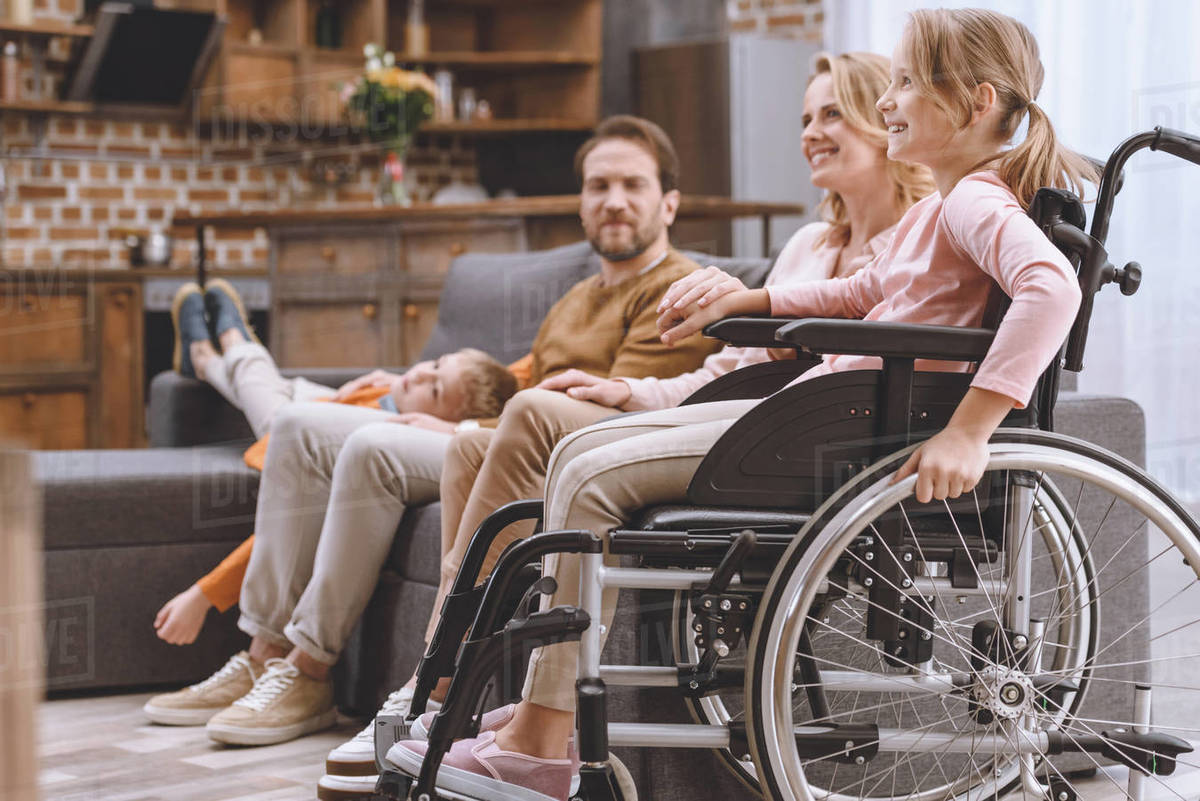 happy family with disabled little daughter in wheelchair spending time ...