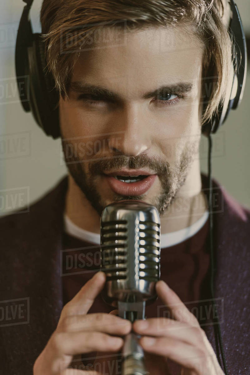 close-up portrait of handsome young singer performing song and looking ...