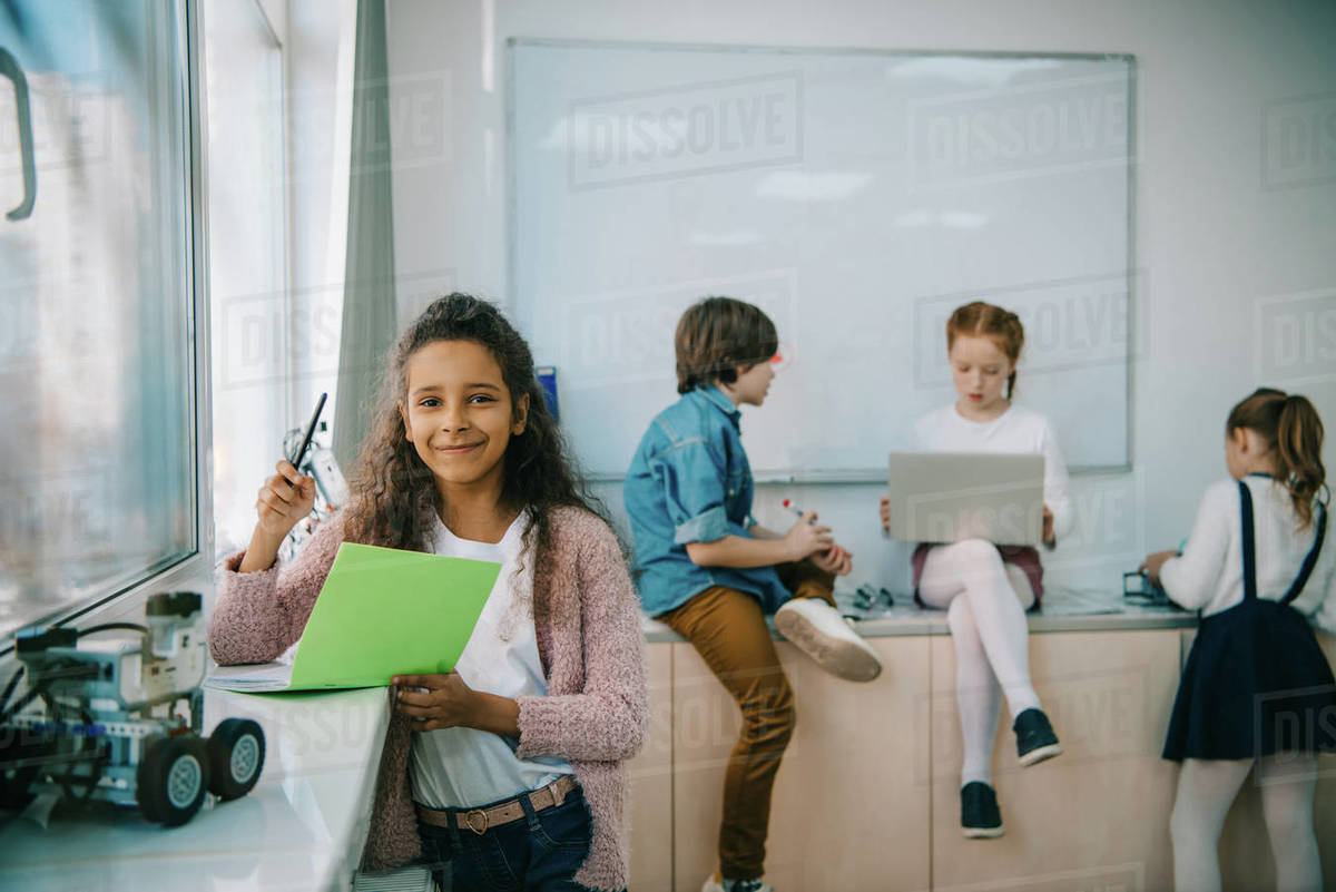 multiethnic group of little kids working together on machinery class ...