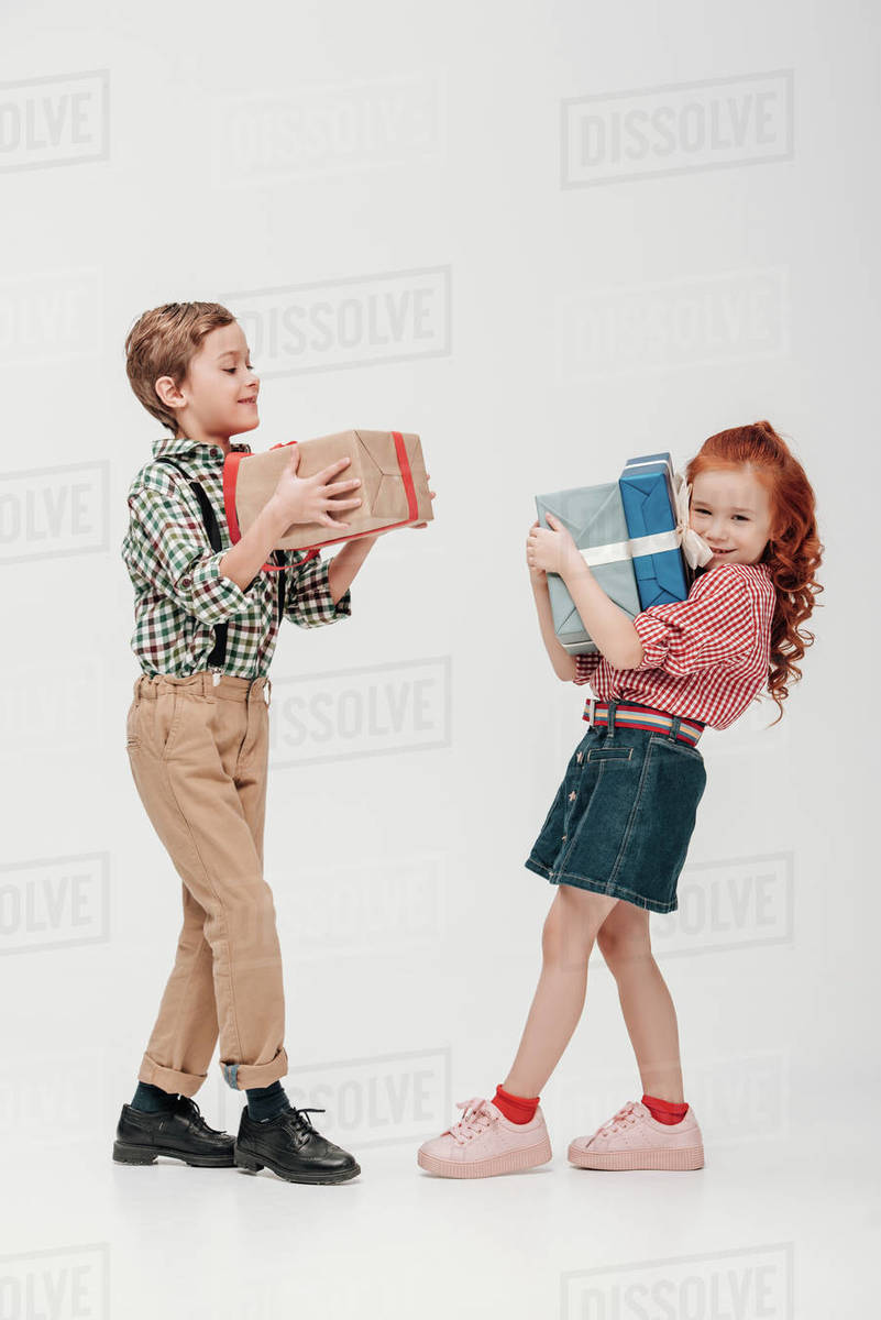 adorable little kids holding colorful gift boxes isolated on grey ...