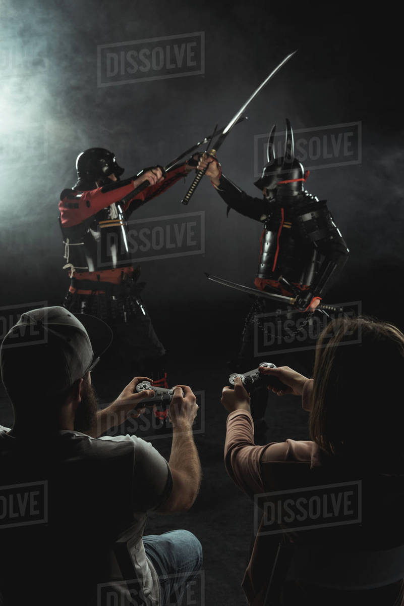 Back view of man and woman playing samurai fighting in real life with ...