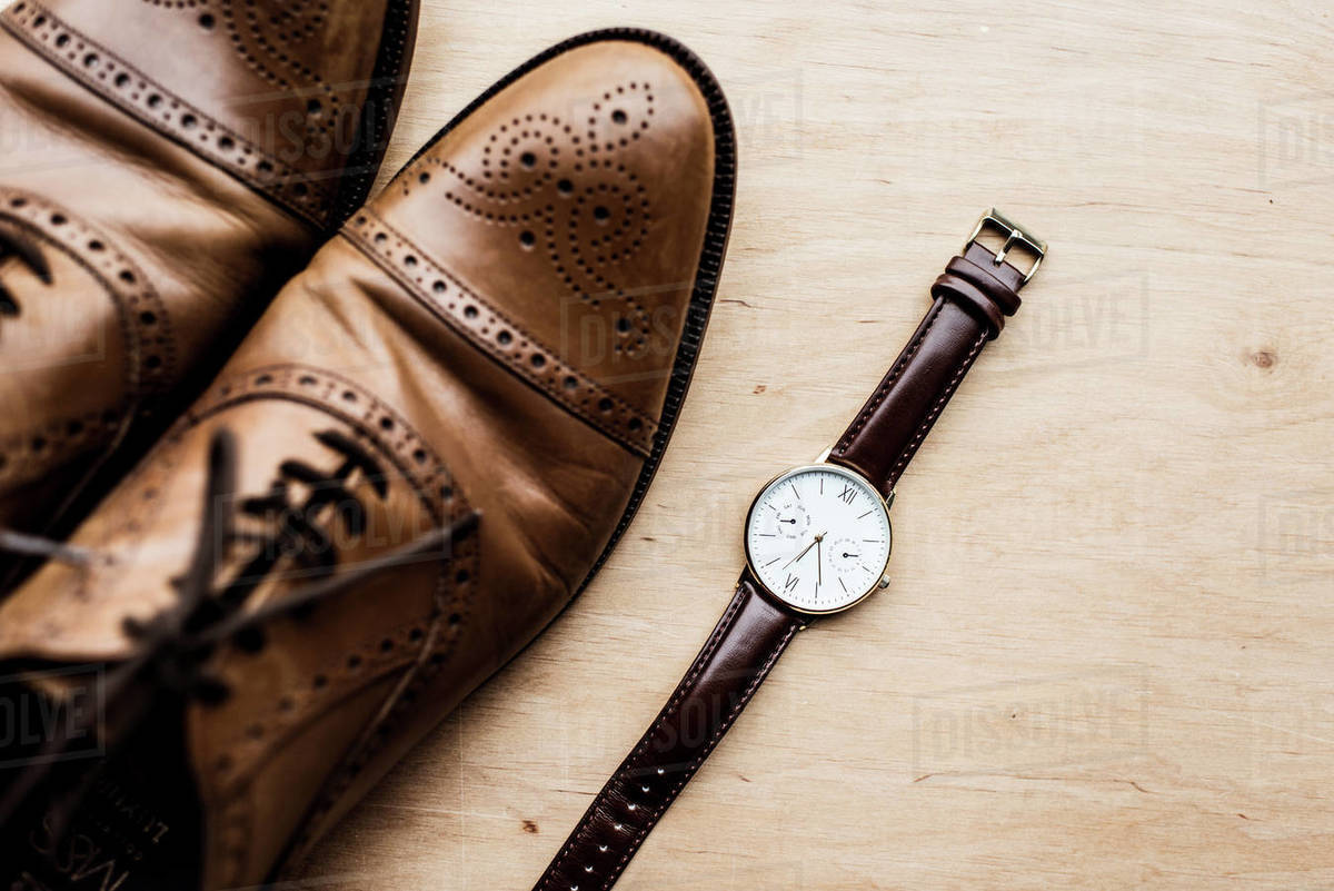 Top view of brown shoes and watch on wooden surface - Royalty-free ...