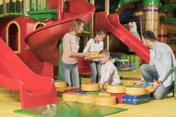 happy family with two little children playing together in game center ...