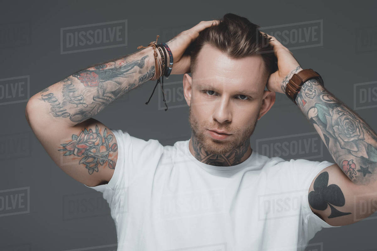 Portrait of handsome stylish young tattooed man in white t-shirt ...
