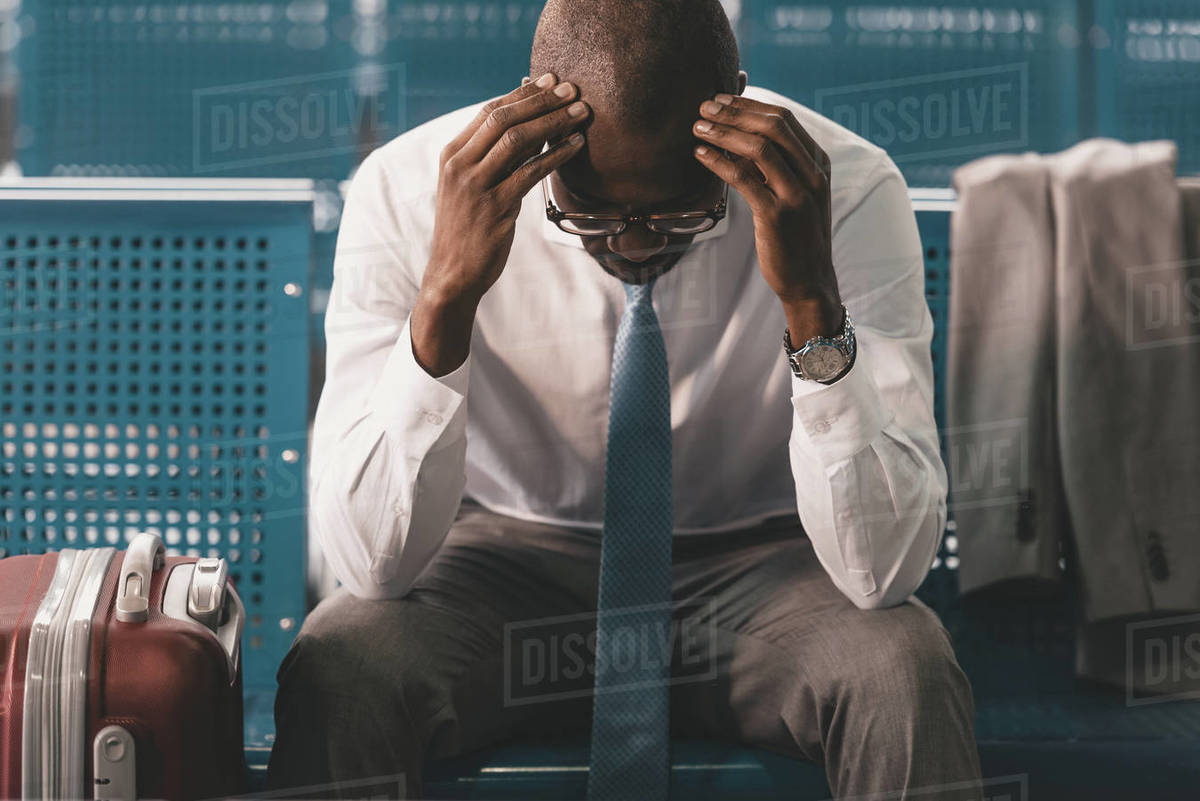 Exhausted businessman waiting for flight at airport lobby - Royalty ...
