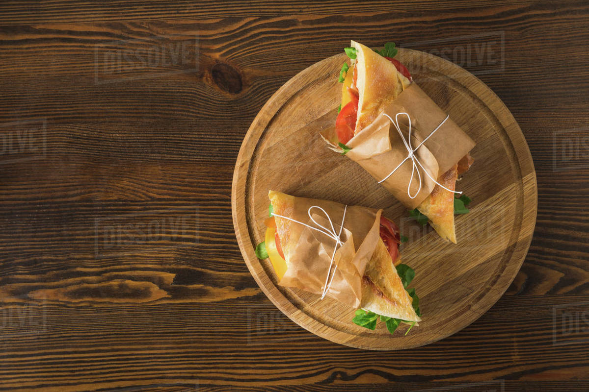 Top view of two delicious panini on cutting board on wooden table ...