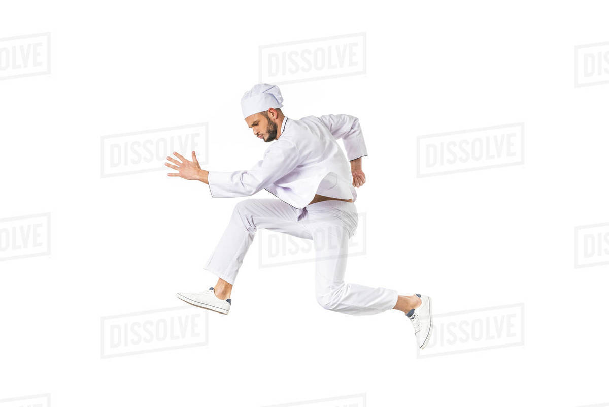Side view of young chef running and jumping isolated on white - Royalty ...
