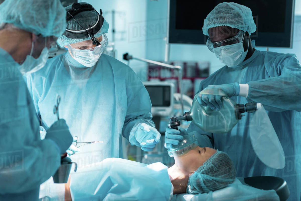African american anesthetist holding oxygen mask above patient in ...
