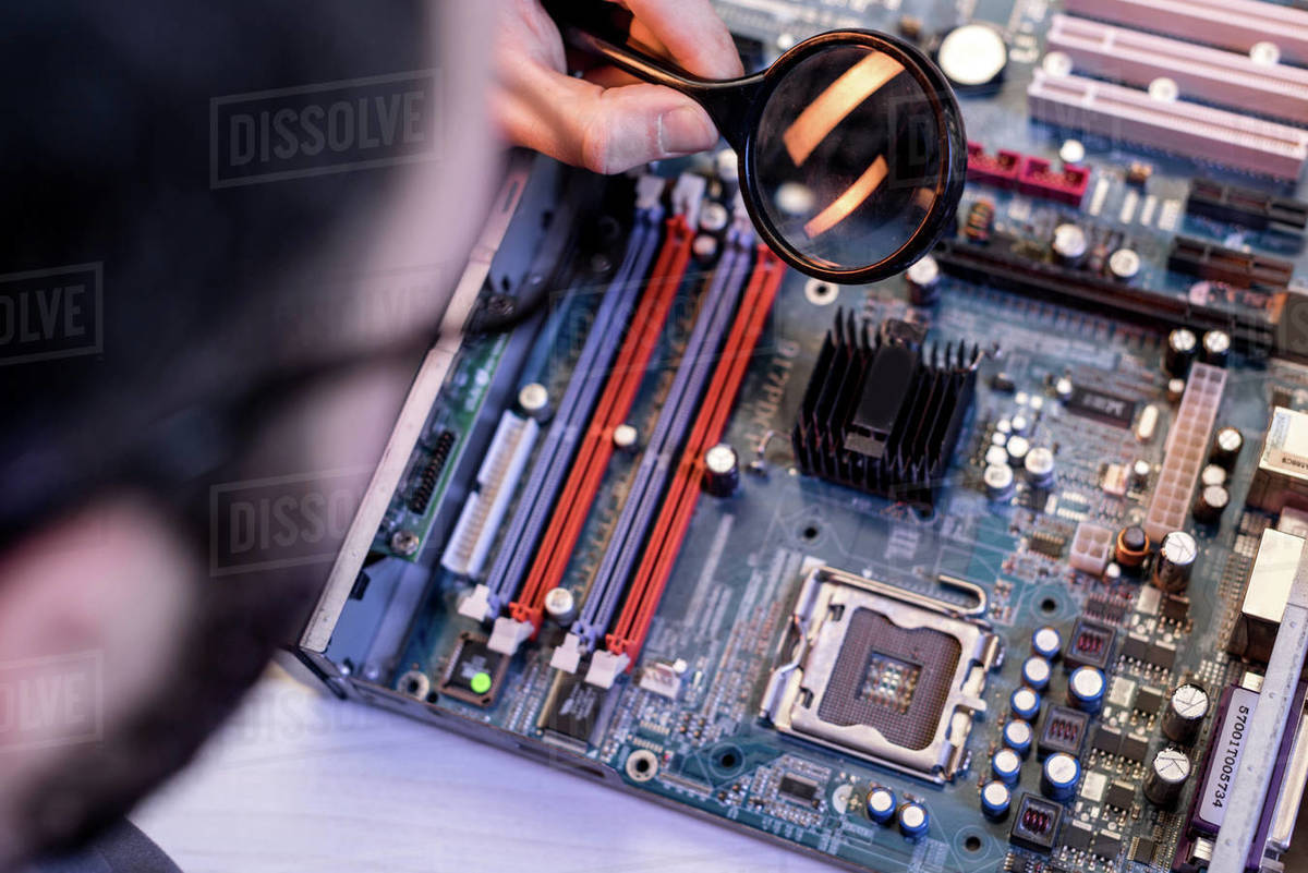 Cropped image of man using magnifier while fixing motherboard - Stock ...