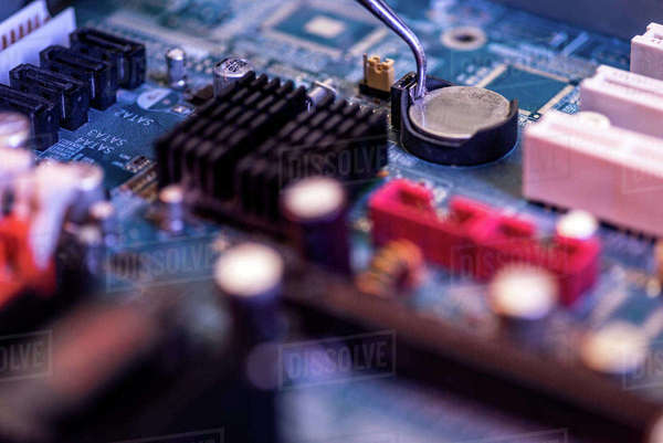Close up of motherboard and battery in socket - Stock Photo - Dissolve