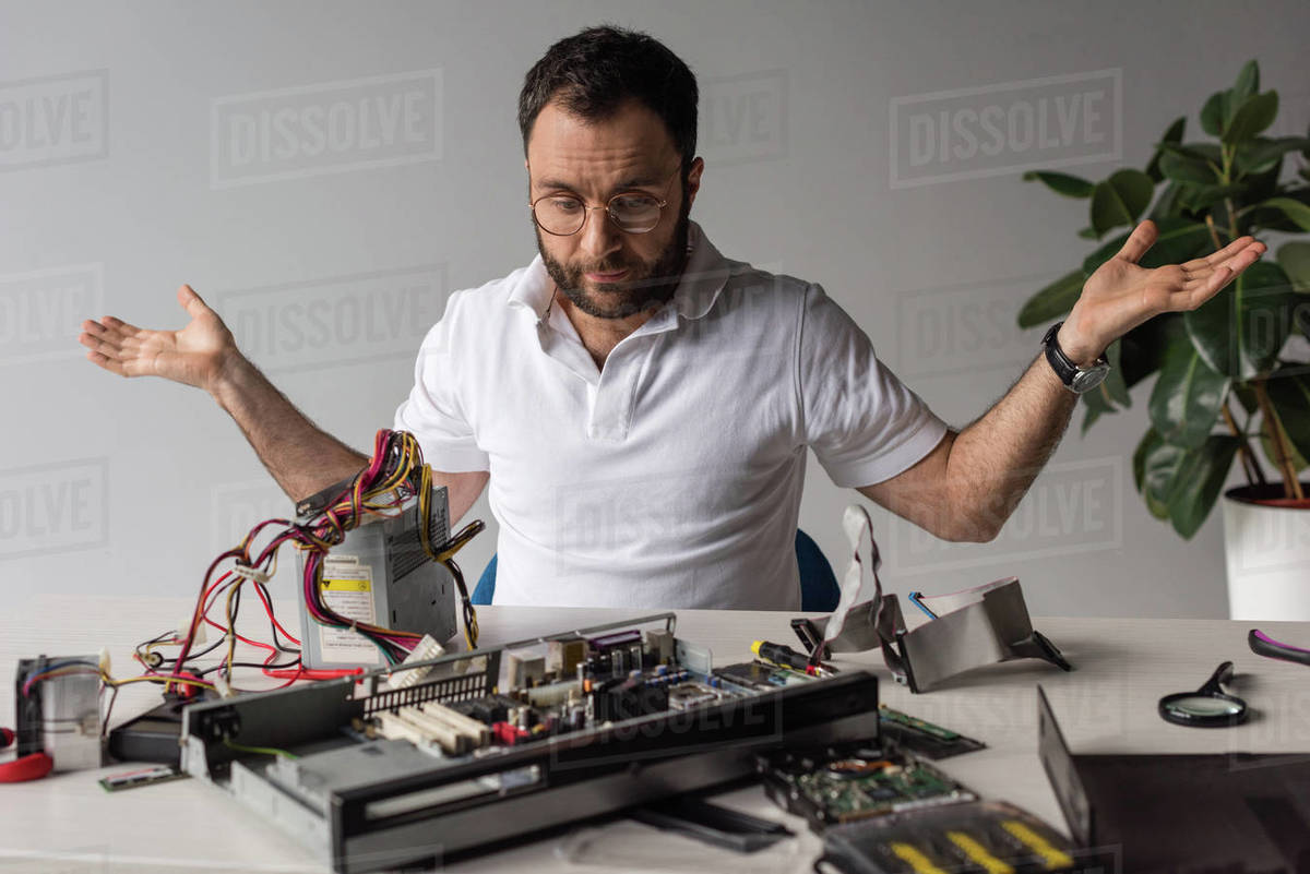 Bewildered man with arms outstretched looking on broken pc - Royalty ...
