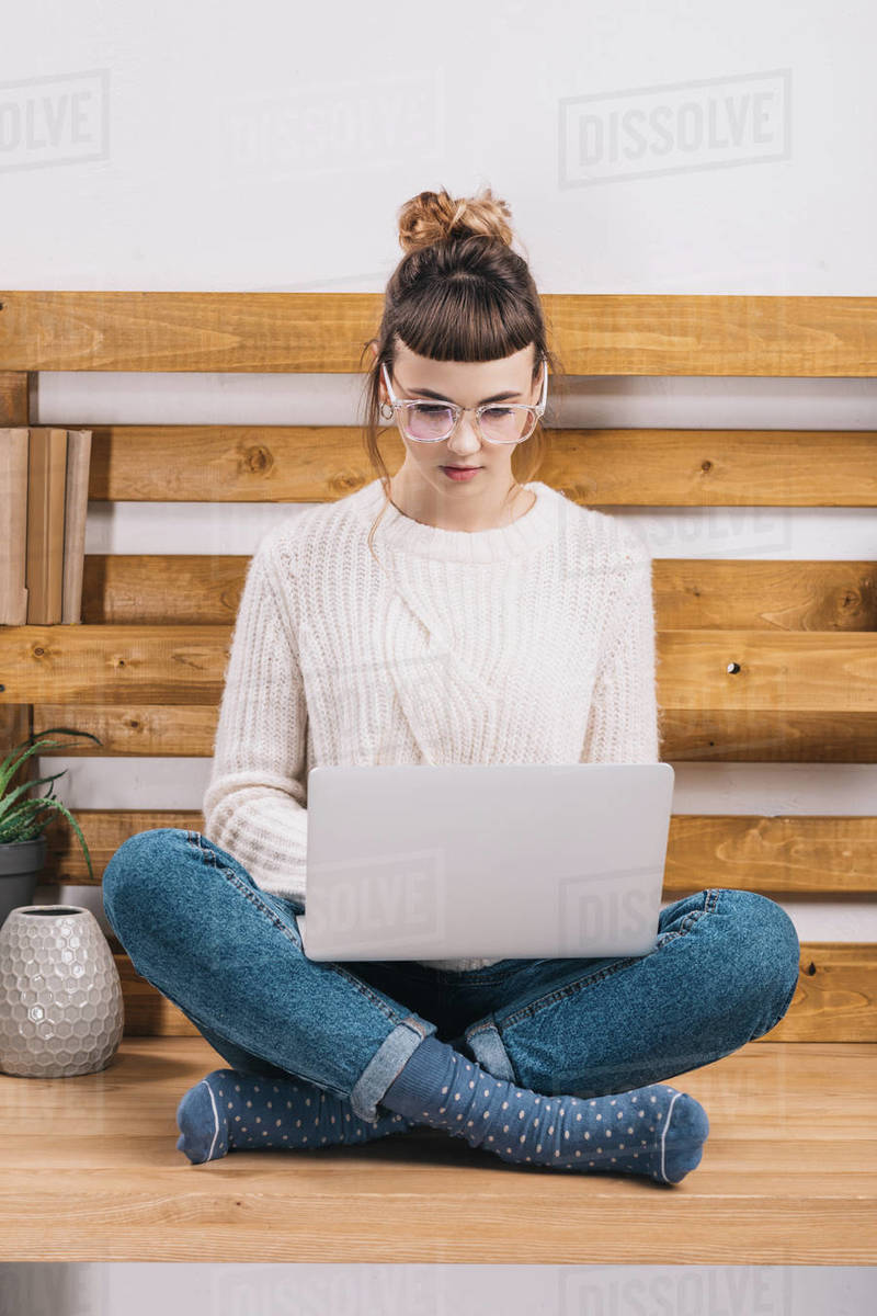 Girl sitting on table with laptop in office - Royalty-free Stock Photo ...