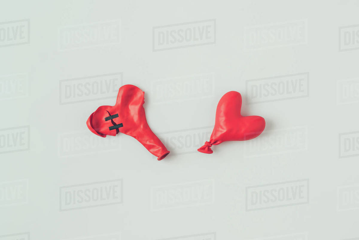 Top view of two deflated heart shaped balloons isolated on white ...