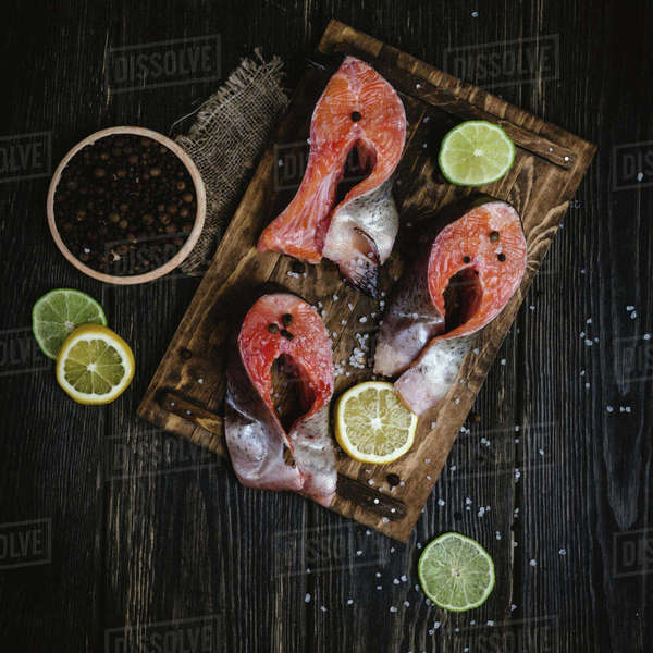 Top view of fresh sliced red fish with spices and citrus fruits on ...