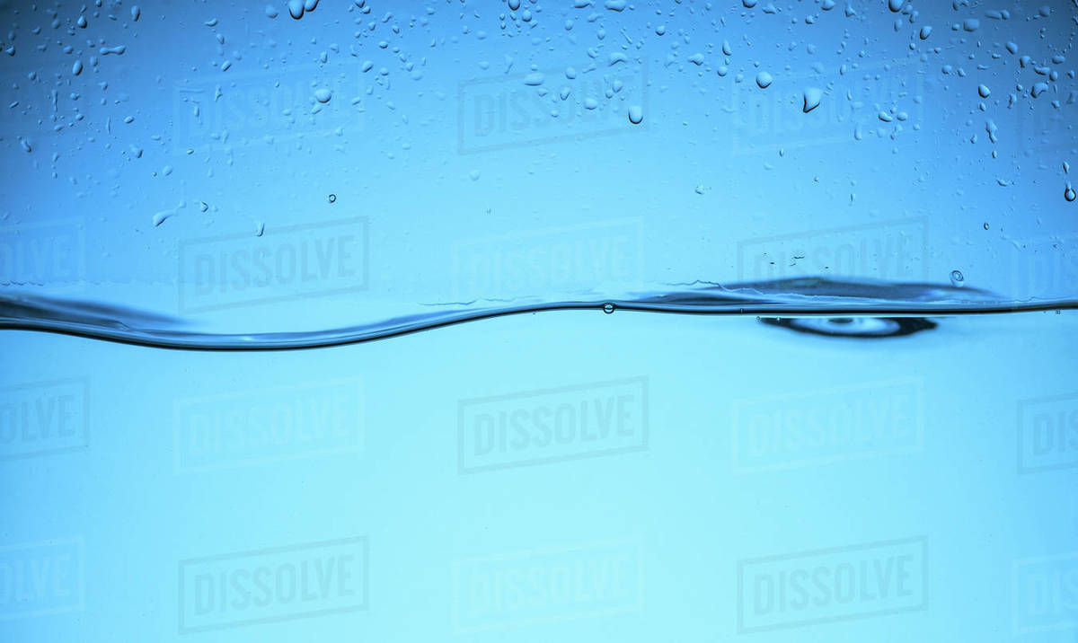 Clear flowing water texture with drops, isolated on blue - Stock Photo ...