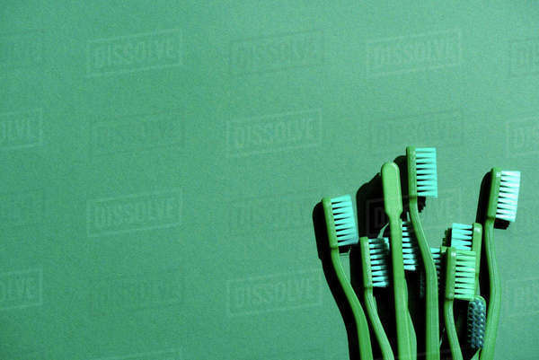Top view of green toothbrushes, on green with copy space - Royalty-free ...