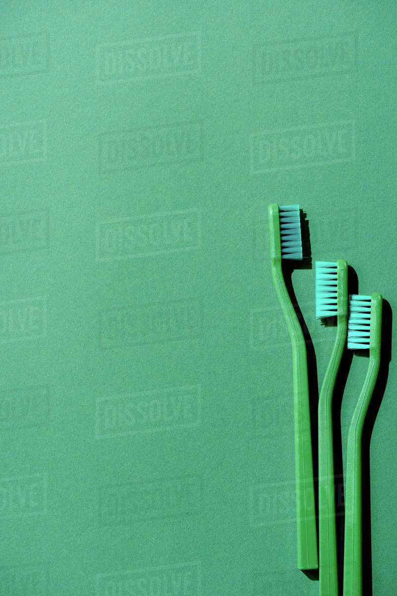 Top view of green toothbrushes, on green with copy space - Royalty-free ...