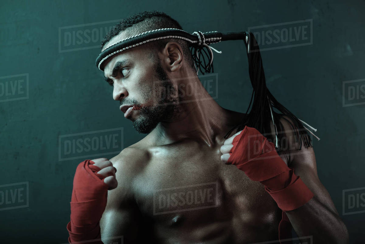 Close-up portrait of determined muay thai fighter with blood on face ...