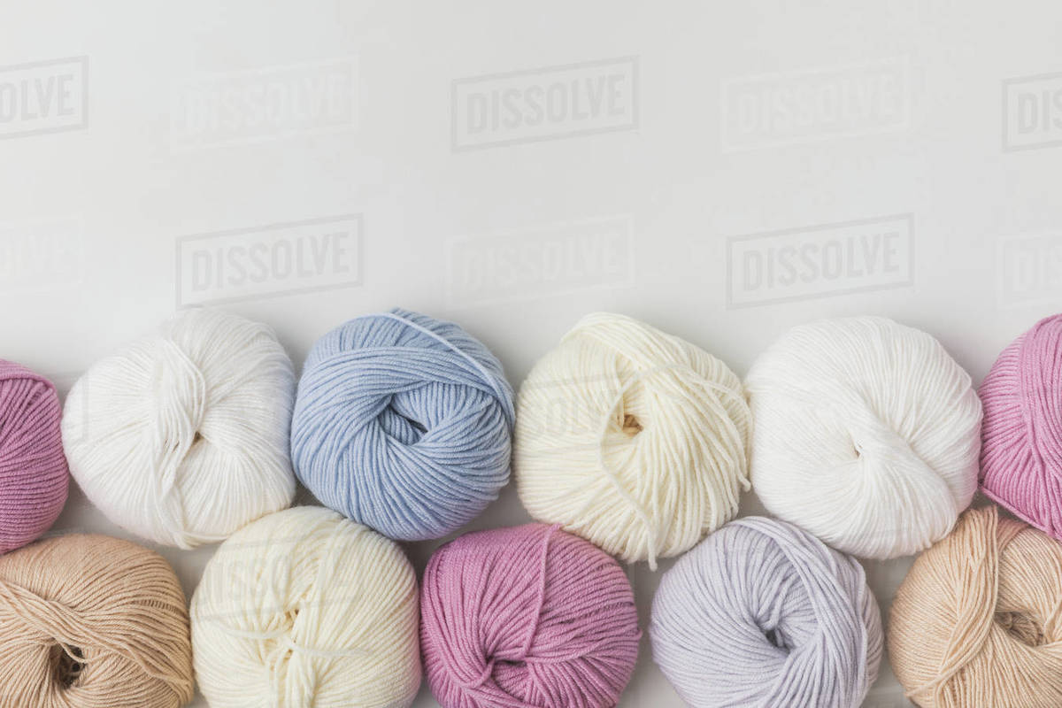 Top view of colored yarn balls in a row isolated on white background ...