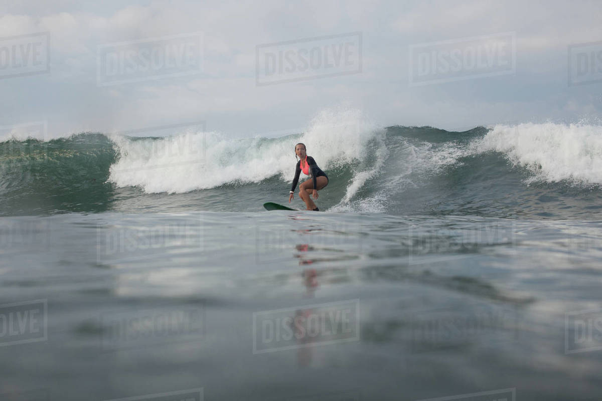 Woman riding wave on surf board in ocean - Royalty-free Stock Photo ...